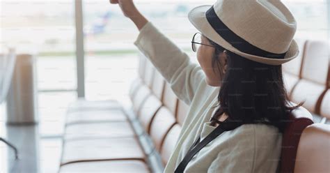 웃고 있는 젊은 아시아 여성 여행자는 국제공항에서 휴가를 보내는 동안 휴대폰이나 스마트폰으로 셀카를 찍고 있다 사진 Unsplash의 현대의 이미지