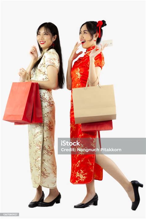쇼핑 컨셉 스타일로 중국 새해 쇼핑백을 들고 흰색 배경에 고립 된 무언가를보고 청삼 드레스를 입은 두 아시아 여성 20 24세에 대한 스톡 사진 및 기타 이미지 Istock