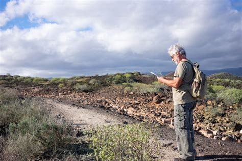 야외 여행에서 편안한 수염을 기른 남자가 배낭을 메고 지도를 참조하고 있다 하이킹과 건강한 라이프 스타일을 즐기는 활동적인 백발 연금 수급자 사진 Unsplash의
