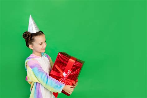 밝은 양복을 입고 모자를 쓰고 녹색으로 고립된 배경을 가진 귀여운 어린 소녀 텍스트 공간입니다 새해와 크리스마스 컨셉 12월에