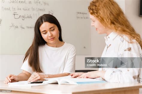 영어 교사는 백인 수업에 학생을 요청합니다 2 여학생 학생 교사에 대한 답변 그룹에서 작업할 수 있습니다 영어와 영국언어를 공부하세요 2명에 대한 스톡 사진 및 기타 이미지