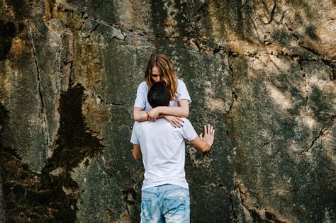 남자와 여자는 스탠드와 포옹 큰 바위 근처에 키스 돌 젊고 세련 되 고 사랑 하는 부부는 서로의 위 길이를 되돌아 봅니다 닫습니다 자연가을 측면 보기 2명에 대한 스톡 사진