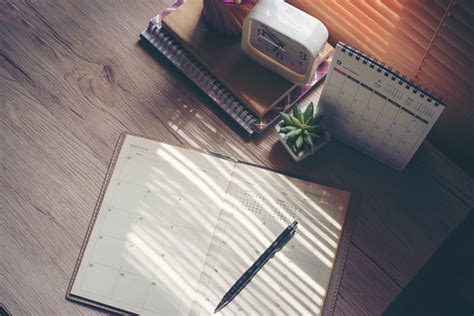 의제 플래너 책 달력 연필 시계가 사무실 책상에 놓여 있습니다 주최자가 방에서 시간표 일일 약속 및 관리 작업을 계획할 수 있는 일기입니다 플래너 책 개념입니다 달력에 대한