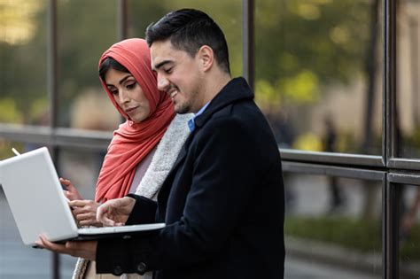 여성 동료에게 노트북에 콘텐츠를 보여주는 행복한 사업가 밖으로 걸어나가는 사업가와 여자 노트북을 사용하고 말하고 웃고 웃고
