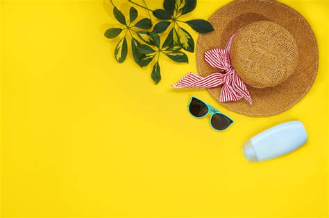 해변 시즌 액세서리 밀짚 모자 선글라스 자외선 차단제 및 노란색 배경에 격리 된 쉐플래어를 남깁니다 상단 보기 플랫 레이 개념에