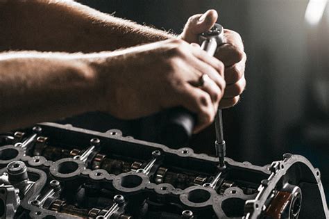 엔진 수리 어두운 수리점에서 회전식 드라이버를 가진 정비공 손 렌치에 대한 스톡 사진 및 기타 이미지 렌치 차 V8