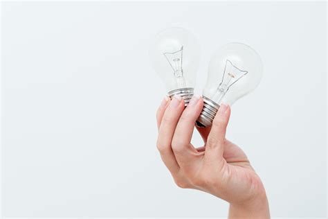 프로젝트 아이디어를 제시하는 램프를 들고 있는 여성 손 전구와 신기술을 보여주는 남자 팜 또 다른 의견을 나타내는 두 개의 전구 개념에 대한 스톡 사진 및 기타 이미지