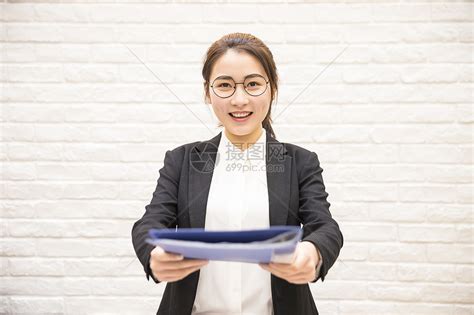 公司年轻前台接待递文件夹高清图片下载 正版图片500844741 摄图网