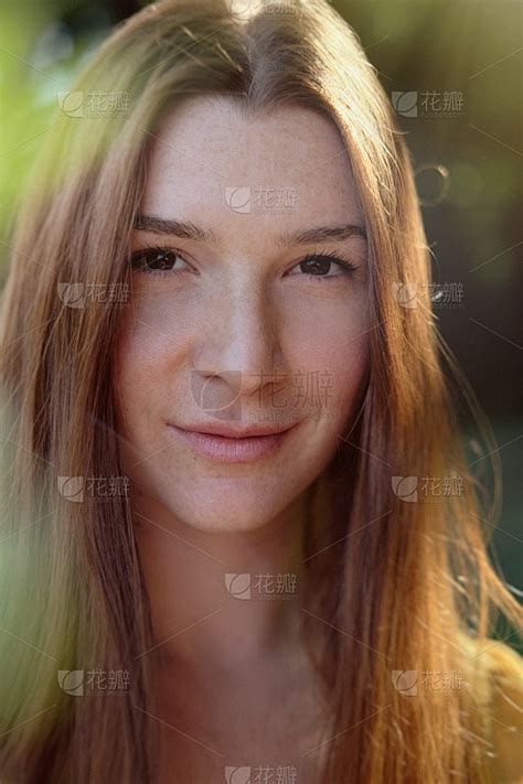 对着镜头微笑的红发年轻女子的肖像