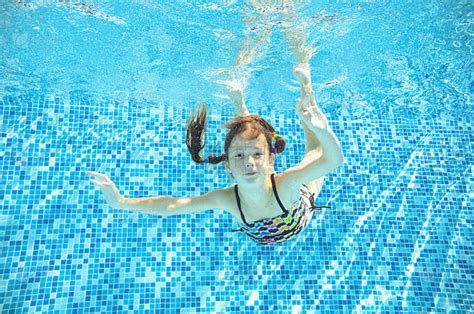女孩在水下的游泳池里跳跃、跳水和游泳