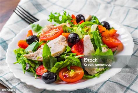 닭 가슴살 아루굴라 검은 올리브 고추 양상추 신선한 연고 잎과 토마토와 신선한 샐러드 나무 테이블 배경에 흰색 접시에 가금류에 대한 스톡 사진 및 기타 이미지 Istock