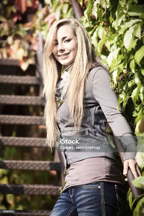 Smiling Teen Girl Standing At Staircase Bottom Looking At Camera Stock
