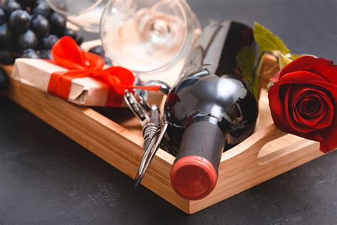 와인 한 병 2 잔 빨간 장미 1 개 리본이있는 선물 상자 어두운 포도 검은 색 배경의 코르크 나사 선물에 대한 스톡 사진 및 기타 이미지 Istock