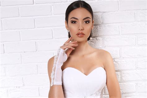 Портрет красивой брюнетки в белом свадебном платье · бесплатная