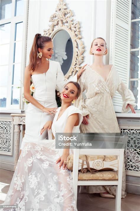 로얄 호텔 방의 풍부한 인테리어에서 포즈를 취하는 흰색 레이스 패션 스타일 드레스의 세 젊은 예쁜 아가씨 럭셔리 라이프 스타일 사람들 개념 결혼식 날 신부 3 명에 대한