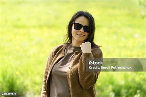 선글라스와 갈색 스웨터를 입은 귀여운 미소녀가 여름에 들판 한가운데에서 포즈를 취하고 있습니다 레저 및 활동 컨셉 35 39세에 대한 스톡 사진 및 기타 이미지 Istock