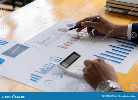 Businessman Holding Pen While Reading Statistics Graph On His Desk Office Work Concept Analysis