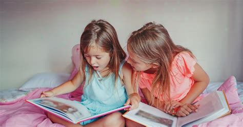 행복한 백인 자매 소녀들은 침실에서 책을 읽고 있다 집에서 함께 시간을 보내는 아이들 어린이 교육 개발 학습 실제 사람들의 정통 라이프 스타일 사진