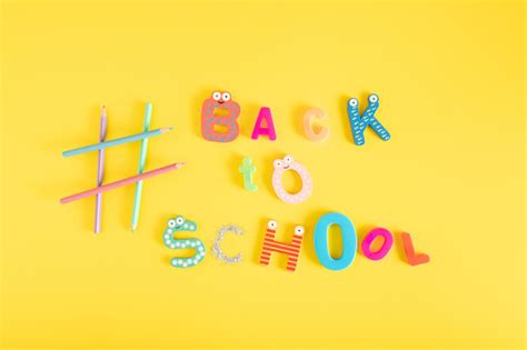 학교로 돌아가 생동감 넘치는 노란색 배경에 플라스틱 장난감 편지와 나무 크레용으로 만든 최소한의 창조적 인 디자인 플랫 레이 교육 배경 3차원 형태에 대한 스톡 사진 및