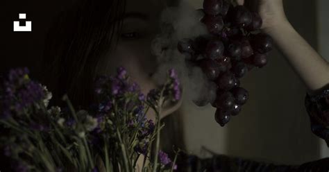 보라색 포도 과일을 들고 과일에 흰 연기를 내뿜는 사람 사진 Unsplash의 무료 회색 이미지