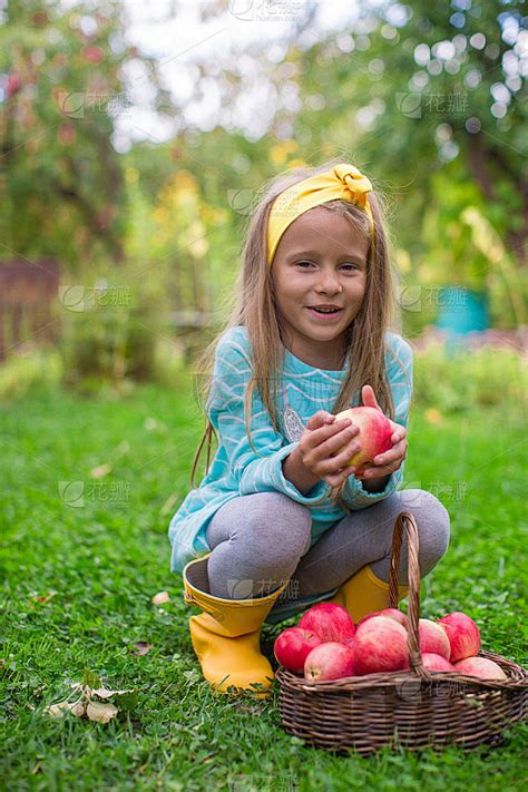漂亮的小女孩拿着一篮子红苹果