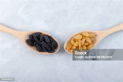 노란색 건포도와 검은 건포도가 회색 배경에 나무 숟가락에 담겨 있으며 상단보기 말린 포도 과일 디자인 요소 0명에 대한 스톡 사진 및 기타 이미지 Istock