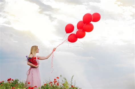 Mädchen Mit Roten Luftballons In Einem Mohnfeld Premium Foto