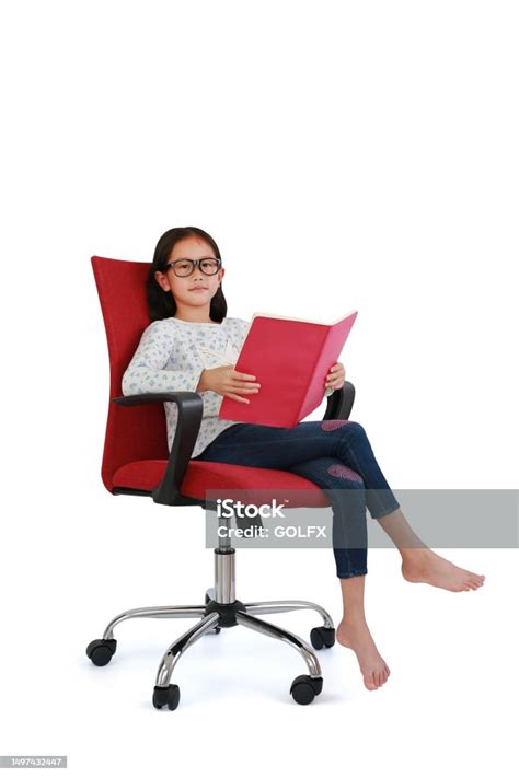 아시아 소녀는 빨간 천 의자에 앉아 책을 읽고 하얀 배경에 고립된 카메라를 본다 클리핑 패스가 있는 이미지 전체 길이 6 7 살에 대한 스톡 사진 및 기타 이미지 Istock