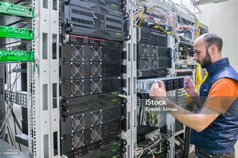 한 남자가 서버 방에서 작동 합니다 시스템 관리자가 최신 데이터 센터에 새 서버를 설치 합니다 엔지니어가 캐비닛의 컴퓨터 장비를 교체 합니다 기술자는 중앙 라우터를 수리