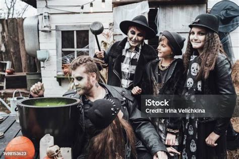 무서운 가족 어머니 아버지 할로윈을 축하하는 딸들 물약의 가마솥 무서운 검은 두개골 하프 페이스 메이크업 마녀 의상 세련된 이미지 공포 거리의 헛간에서 어린이 파티에서의