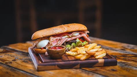 Flavorful 가공육 감자튀김 계란 고기 과테말라 길거리 음식 나무 쟁반 나무 표면 델리 고기 러스틱 맛있는 먹음직스러운 목조 테이블 바삭바삭한