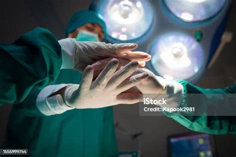 의사와 팀은 병원의 조명 장비가 있는 밝은 현대식 수술실에서 손을 조정합니다 개념 성공을 위한 병원에서의 팀워크 일과 팀에 대한 신뢰 20 24세에 대한 스톡 사진 및 기타