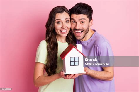 분홍색 파스텔 색상 배경에 고립 된 주택 신용 대출 은행을 들고있는 사랑스러운 놀란 쾌활한 부부의 초상화 2명에 대한 스톡 사진 및 기타 이미지 Istock