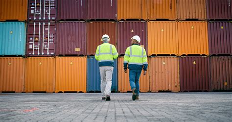 컨테이너 검사 및 물류 또는 공급망을 위해 선적장에서 걷는 남성과의 팀워크 재고목록 저장 및 납품 수출 또는 뒤에서 수입품을 위한 화물 배경에 품질 관리 2명에 대한 스톡