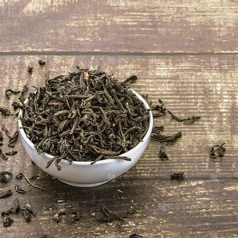 把干茶倒进放在木板桌上的瓷杯里