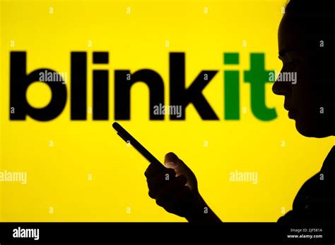 In This Photo Illustration The Blinkit Logo Is Seen In The Background Of A Silhouetted Woman