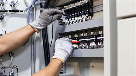 전기 엔지니어는 유지 보수를 위해 정기적으로 전기 제어 캐비닛의 작동을 테스트합니다 전기 연료 및 전력 생산에 대한 스톡 사진