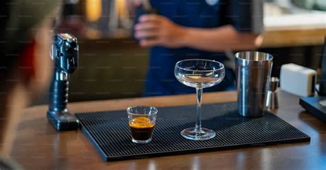 아시아 남자 바리스타가 셰이커에서 아이스 블랙 커피를 흔들고 커피숍의 바 카운터에서 칵테일 잔을 따르고 있습니다 고객에게 차가운 음료를 제공하는 남성 커피 숍 주인 중소