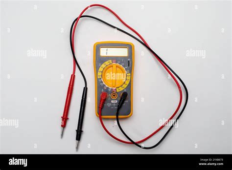 Yellow And Gray Digital Multimeter With Probes Showing One On Display Resting On White