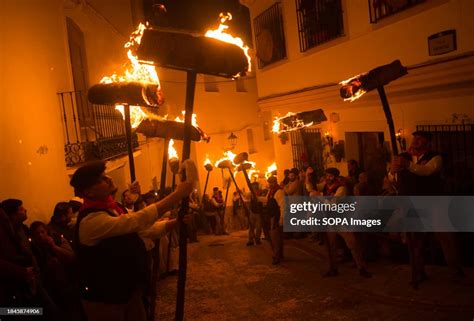 Villagers Are Seen Holding Torches On A Street As They Take Part In