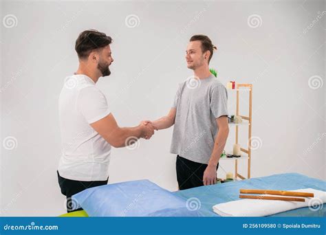 Attractive Masseur Man Shaking Hands With His Client At The End Of Procedure At The Spa Salon In