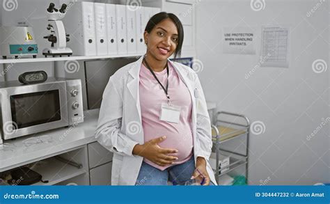Smiling Young Pregnant Scientist Confidently Massaging Her Belly While