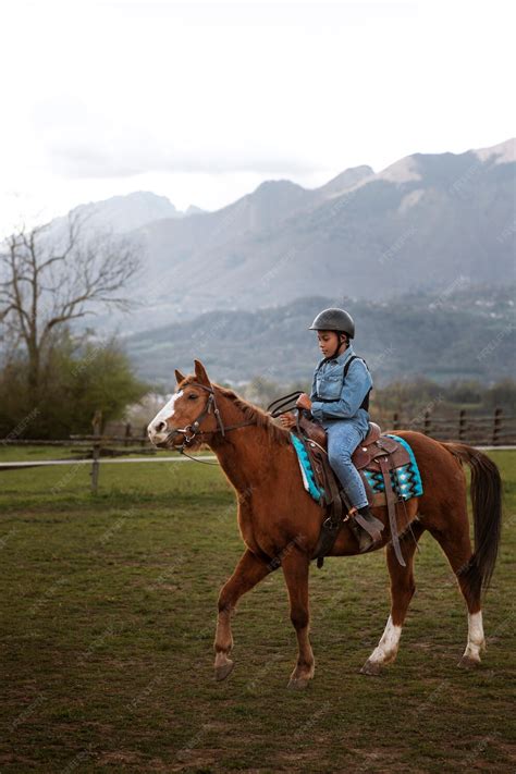 Молодой мальчик учится кататься на лошади Бесплатно Фото