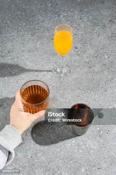 콘크리트 표면에 다른 음료와 함께 음료 한 잔을 들고 있는 사람의 손 따르기에 대한 스톡 사진 및 기타 이미지 따르기 마시기 마실 것 Istock