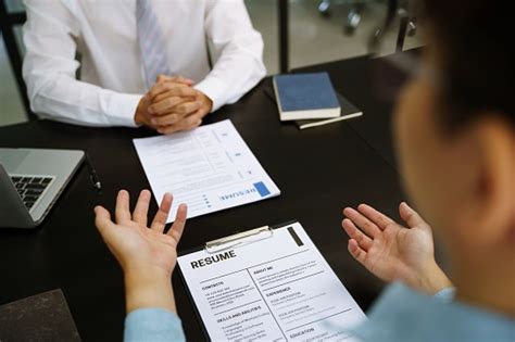 팀 리더 코치는 젊은 근로자들에게 비즈니스 플랜을 위한 논문에 대해 설명하고 사무실에서 새로운 프로젝트 프레젠테이션 을 논의합니다 2명에 대한 스톡 사진 및 기타 이미지