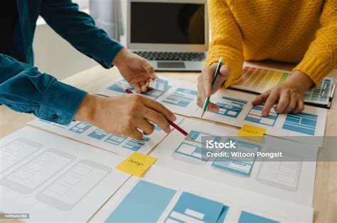 ux 개발자와 ui 디자이너가 현대 사무실에서 고객 요약 및 색상 코드와 함께 테이블에 모바일 앱 인터페이스 와이어프레임