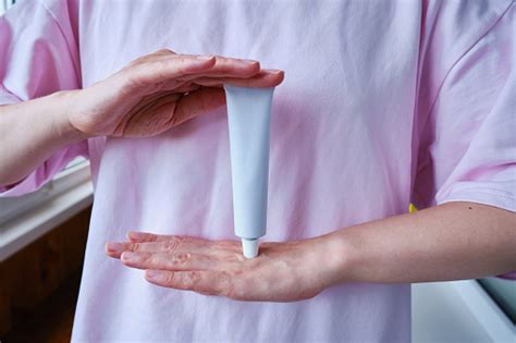 약물 또는 화장품 브랜딩을 위한 세련된 금속 튜브 크림 젤 스킨 케어 치약 소녀의 손에 화장품 병을 담는 용기 미니멀리즘 건강관리와 의술에 대한 스톡 사진 및 기타 이미지