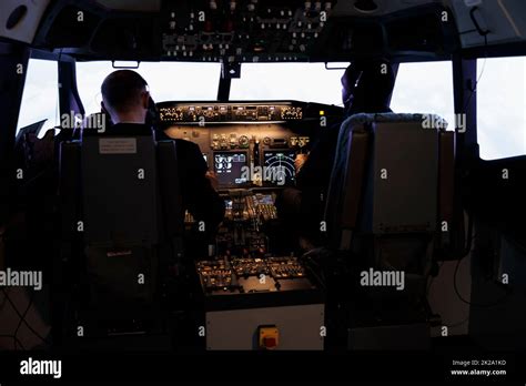 Diverse Team Of Aircrew Members Using Control Command To Fly Plane In Aircraft Cockpit Pushing