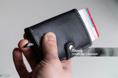 스마트 미니멀 한 지갑 카드 이젝터 2 고립된 흰색 배경에 신용 카드를 꺼내검은 가죽 지갑을 들고 남자의 손을 닫습니다 Rfid 보호 기능이 있는 패셔너블하고 슬림한 지갑