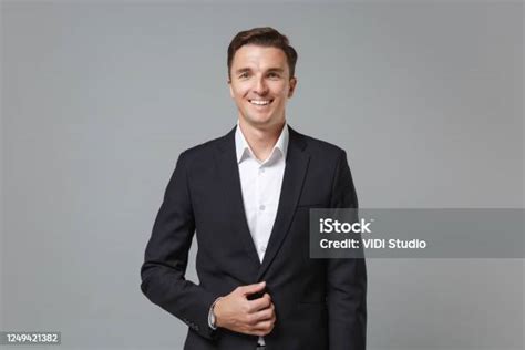 회색 배경 스튜디오 초상화에 고립 포즈 고전적인 검은 정장 셔츠에 성공적인 젊은 사업가 를 미소 성취 경력 재산 사업 개념 복사 공간을 모의합니다 카메라를 찾고 있습니다